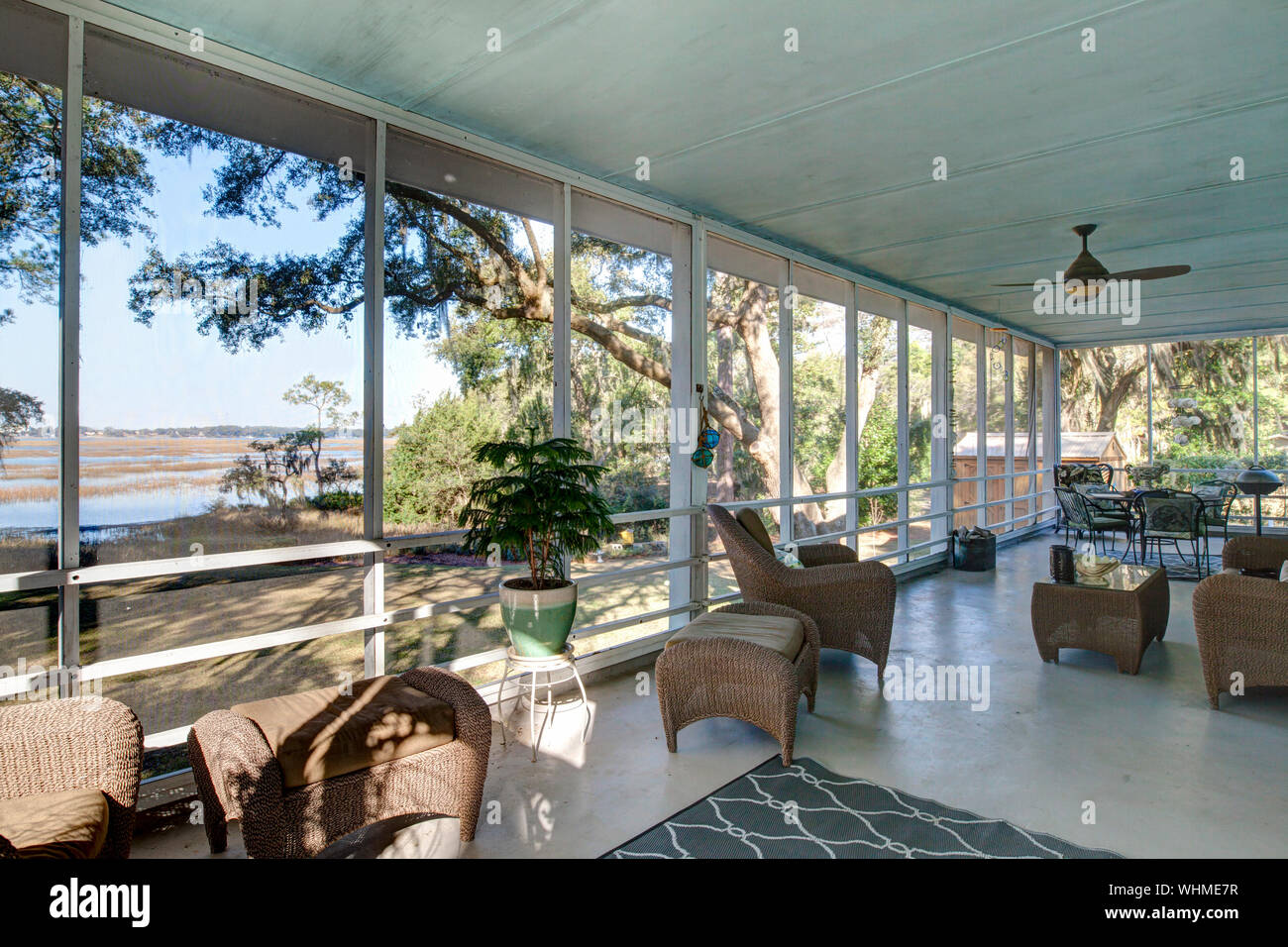 Outdoor screen porch with watefront view and furniture Stock Photo - Alamy