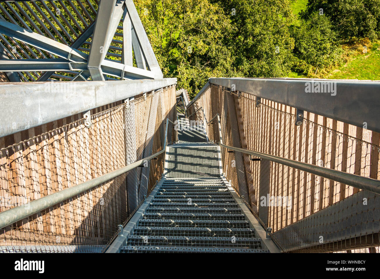 A stair with metal grid steps mounted in a wooden tower in the nature ...