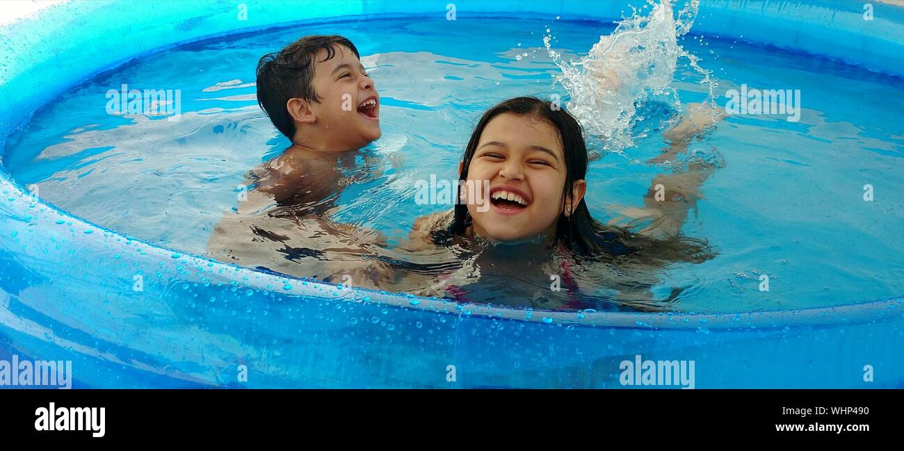 Brother sister playing in pool hi-res stock photography and images - Alamy