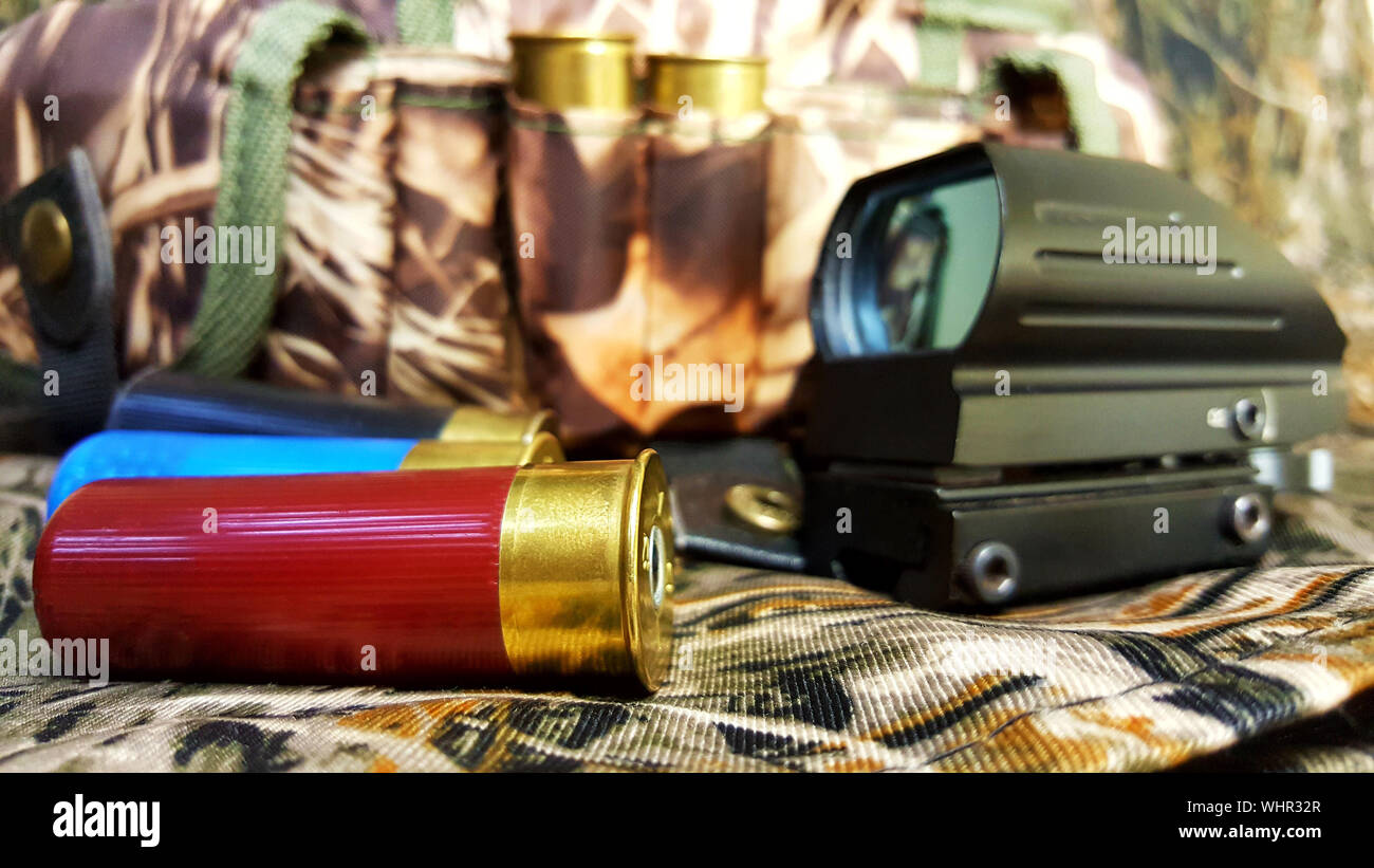 red dot sight and ammunition on camouflage background, wallpaper Stock ...