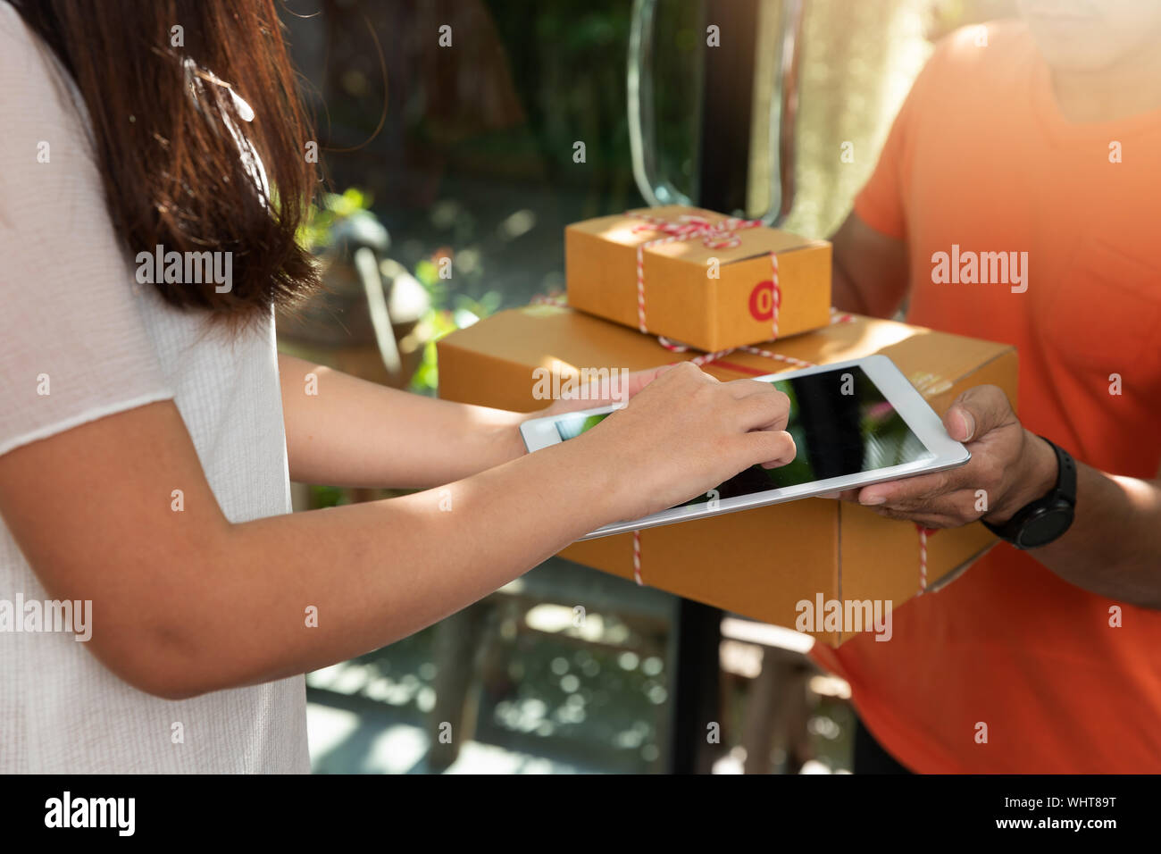 Customer sign signature in digital tablet after receiving parcel from ...