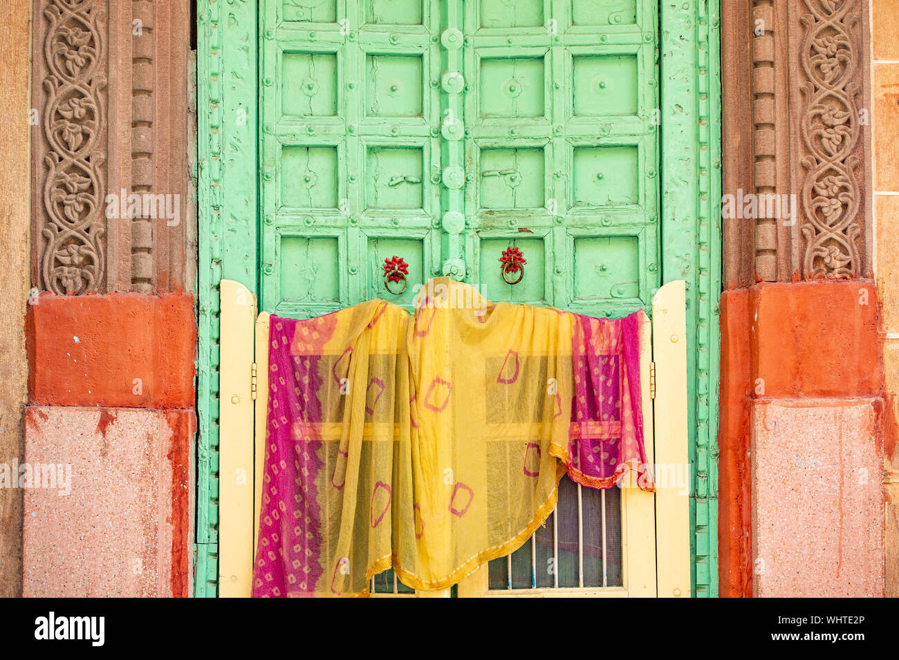 Stunning view of a traditional Indian home with a green wooden door and ...