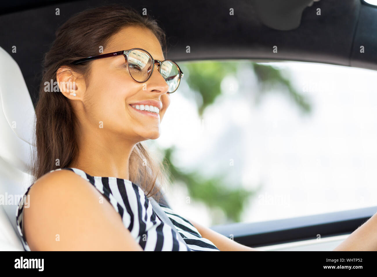 Appealing young woman smiling while driving her car Stock Photo - Alamy