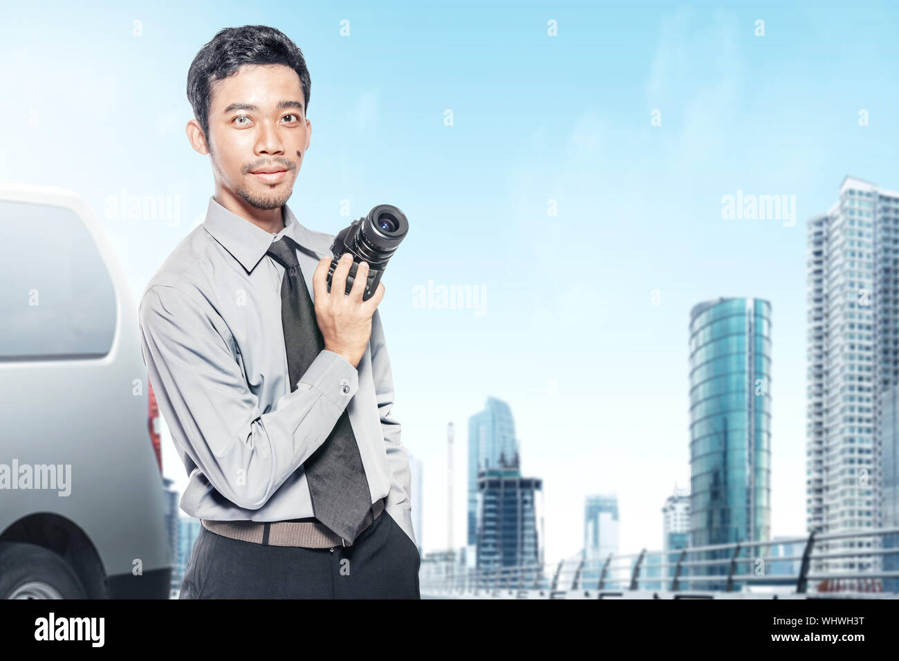 Asian businessman holding the camera on his hand standing on the ...
