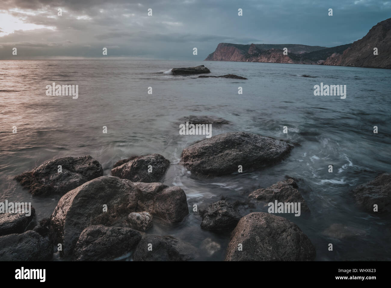 Long exposure of sea and rocks. Wispy Sunset taken with long shutter ...