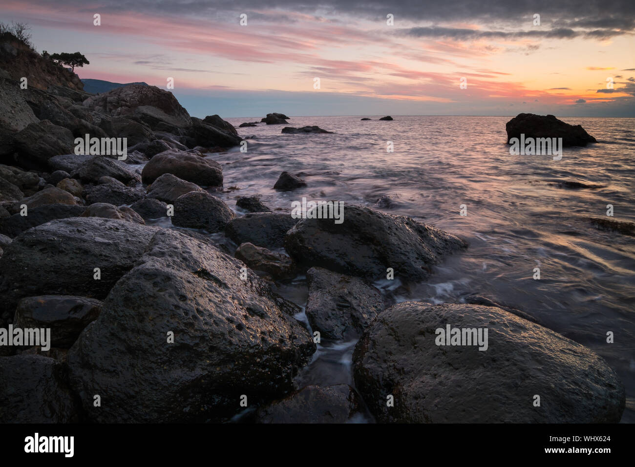 Long exposure of sea and rocks. Wispy Sunset taken with long shutter ...