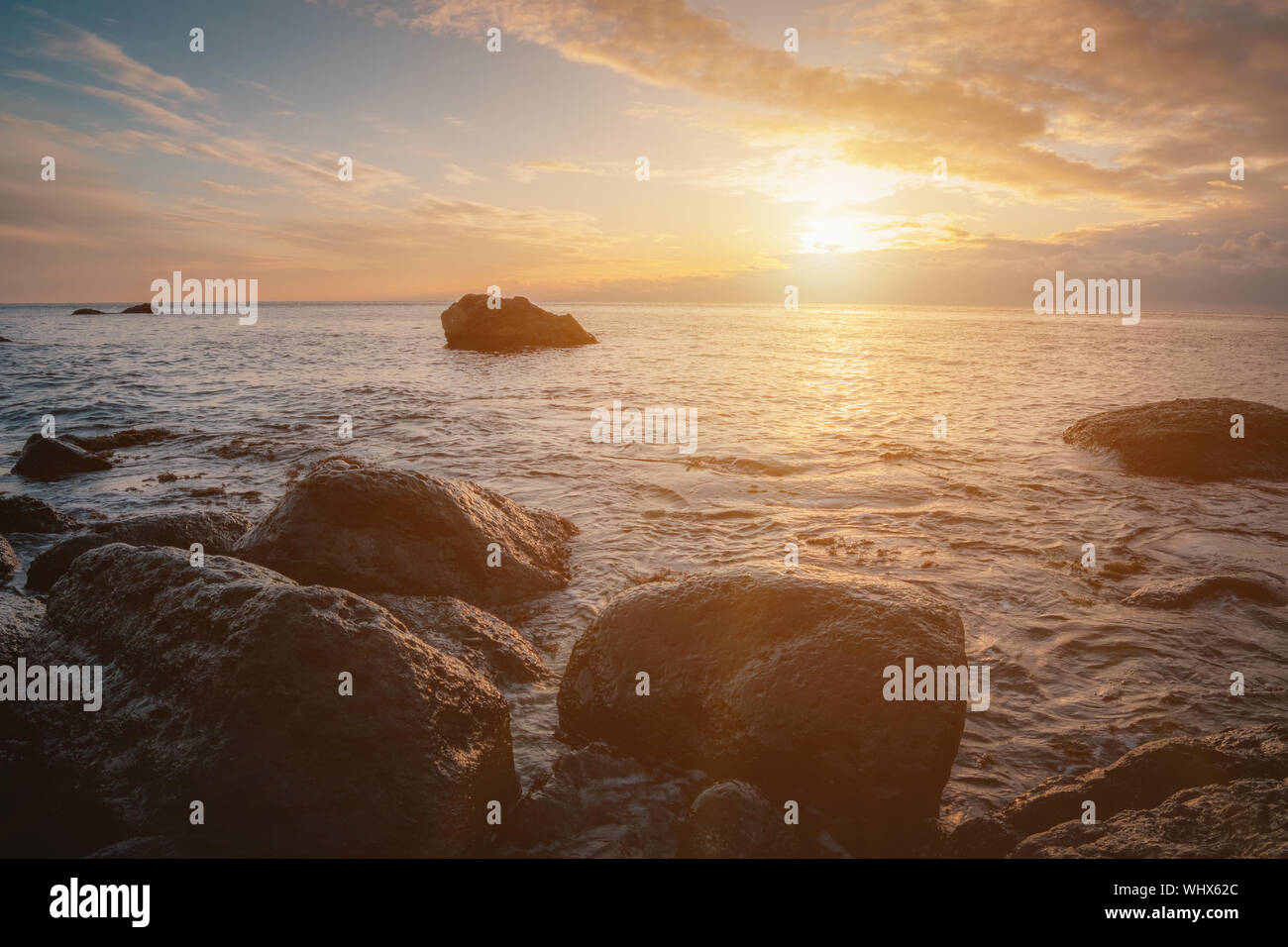 Long exposure of sea and rocks. Wispy Sunset taken with long shutter ...