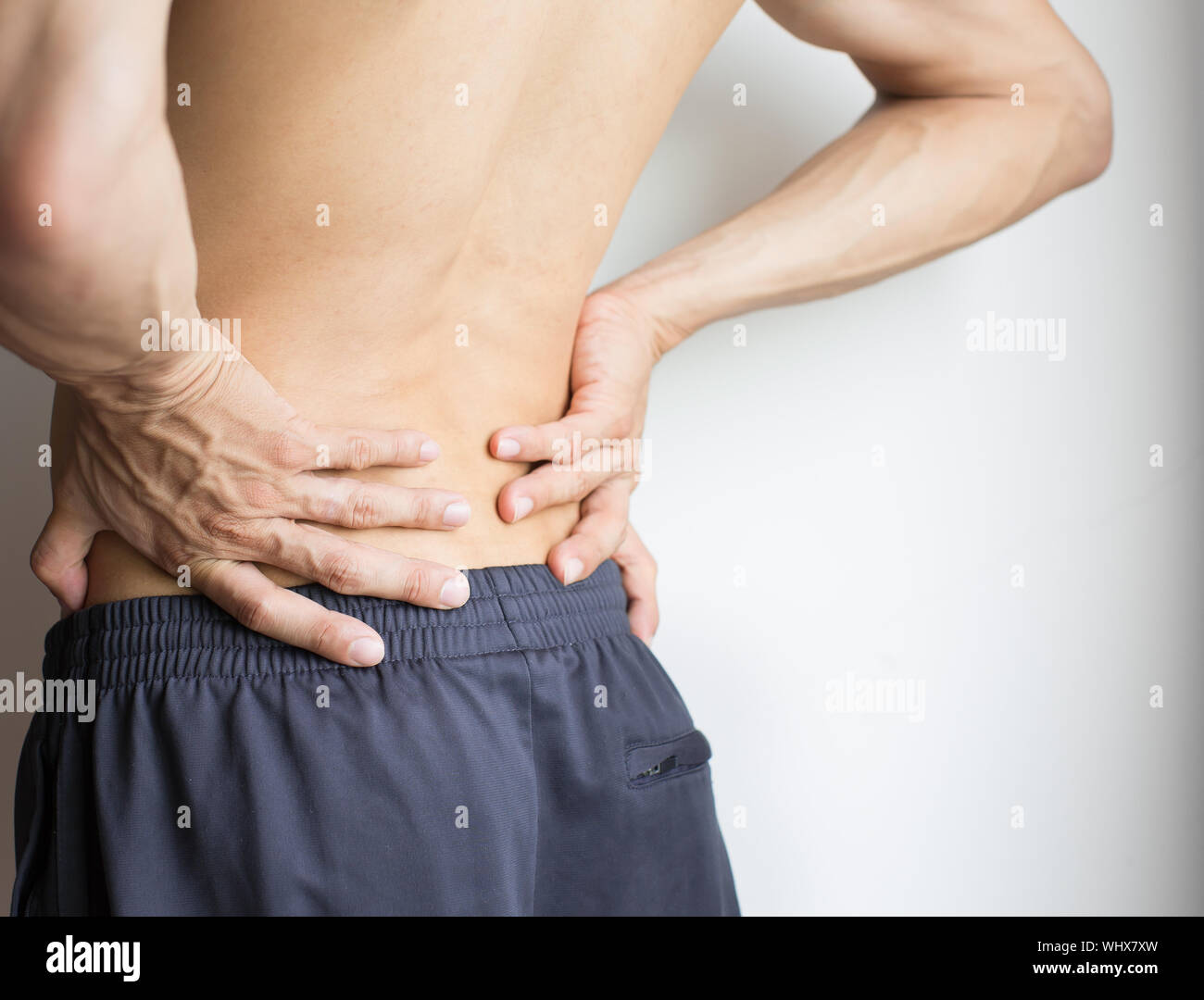 Athletic young man, lower back pain Stock Photo - Alamy