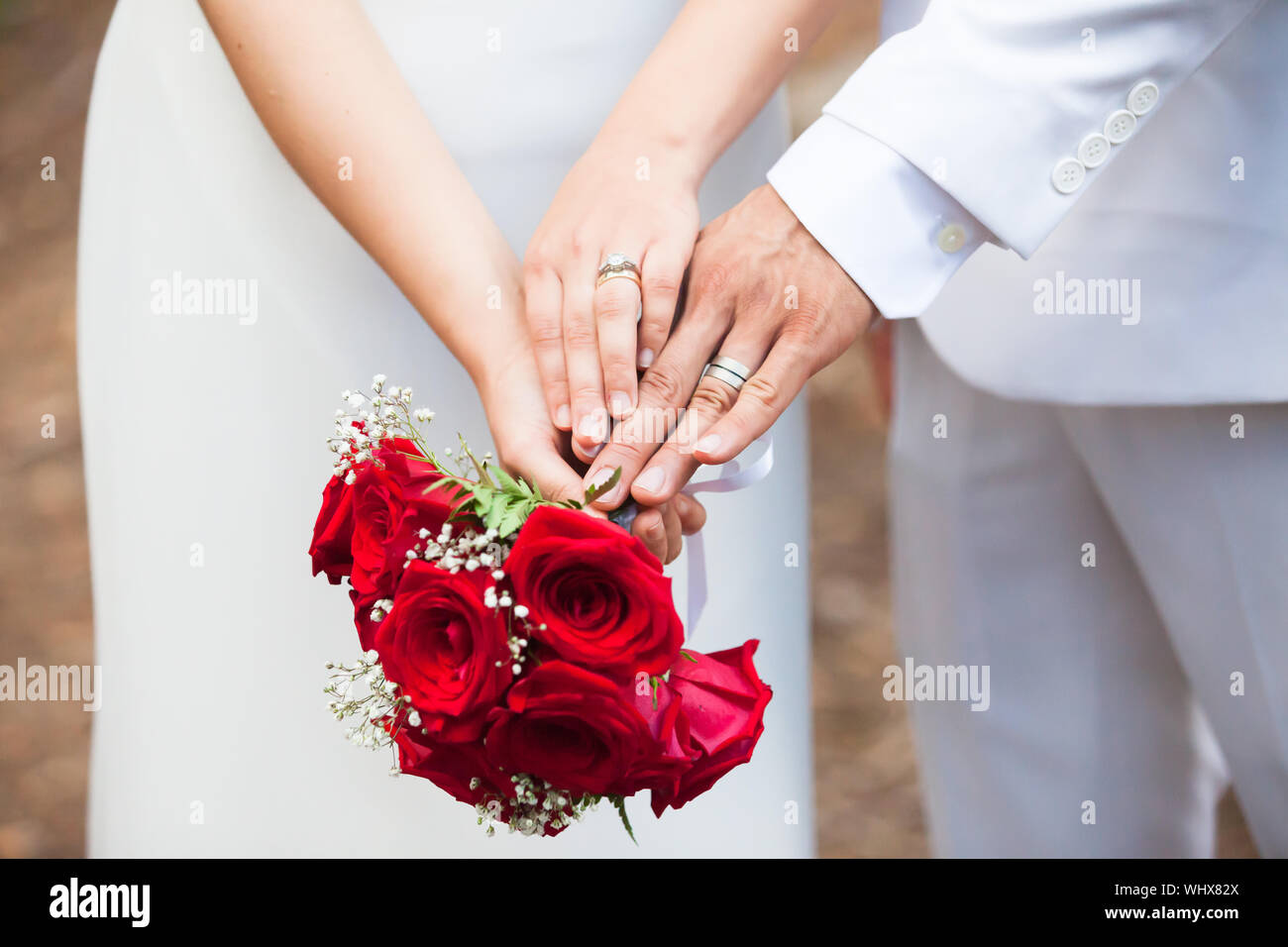 Just married couple compare their wedding rings while holding each ...