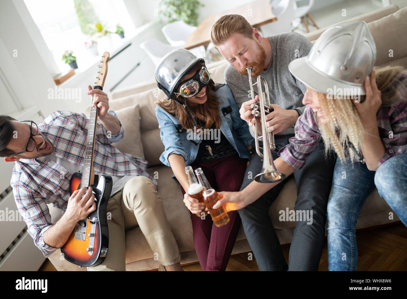 Group of young friends having fun together and playing in music band ...