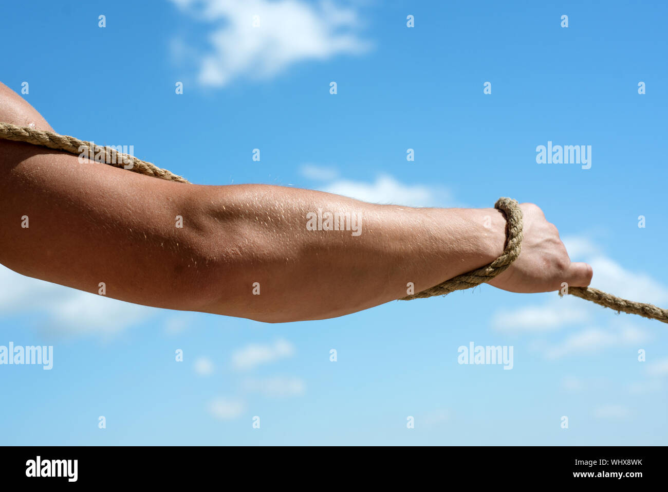 Having strength in his muscles. Male muscular hand pulling rope. Strong ...