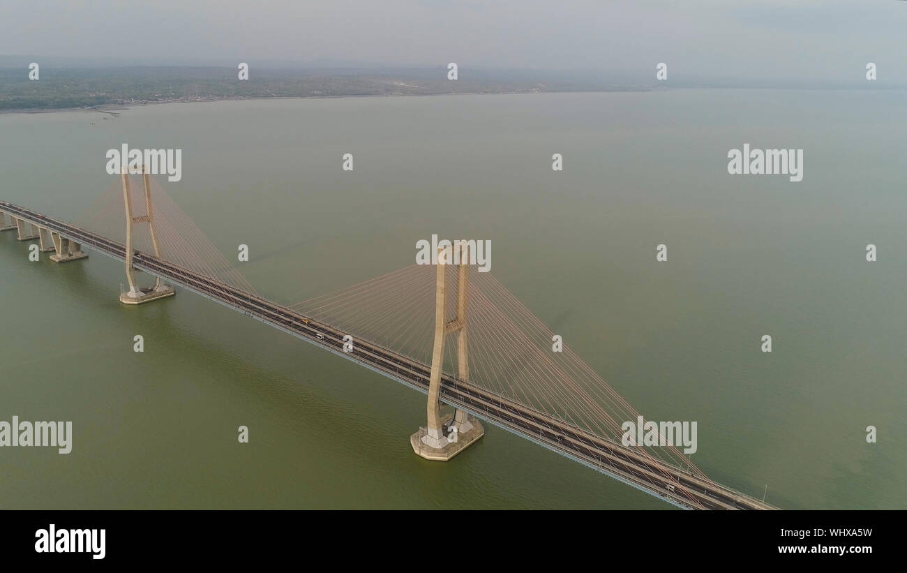 suspension bridge over madura strait with highway and car, surabaya ...