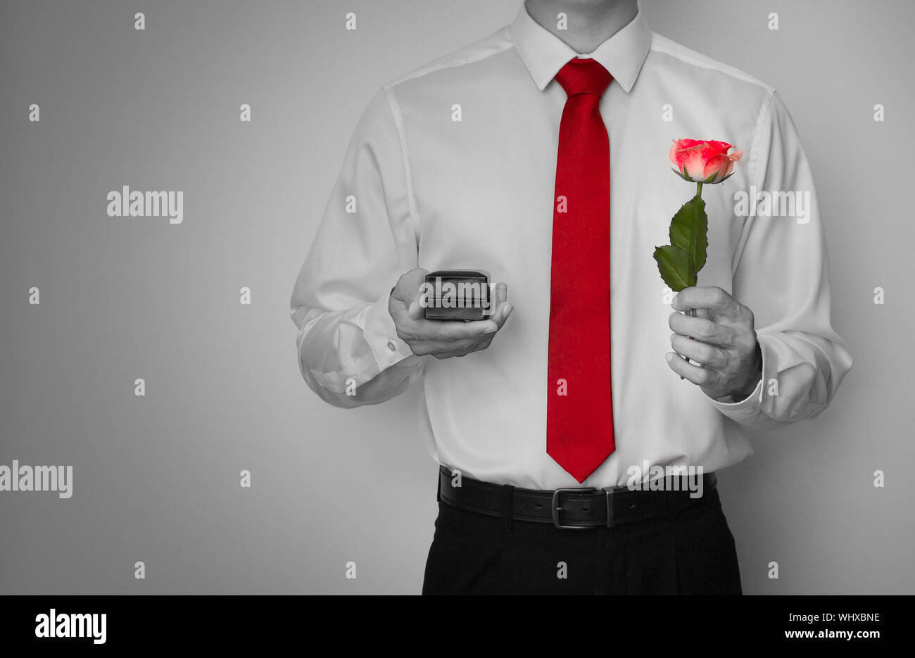 Boy proposing to his love. Black and white photo with the red tie and ...