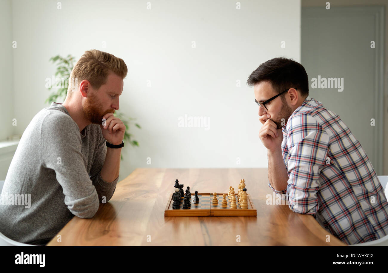 Young smart friends playing chess at home Stock Photo - Alamy