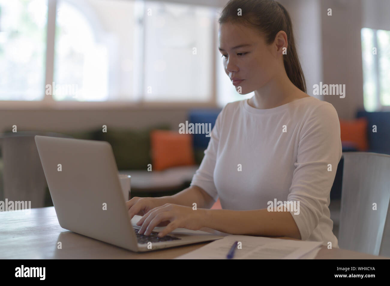 A profession female worker doing work on on her laptop with lots of ...