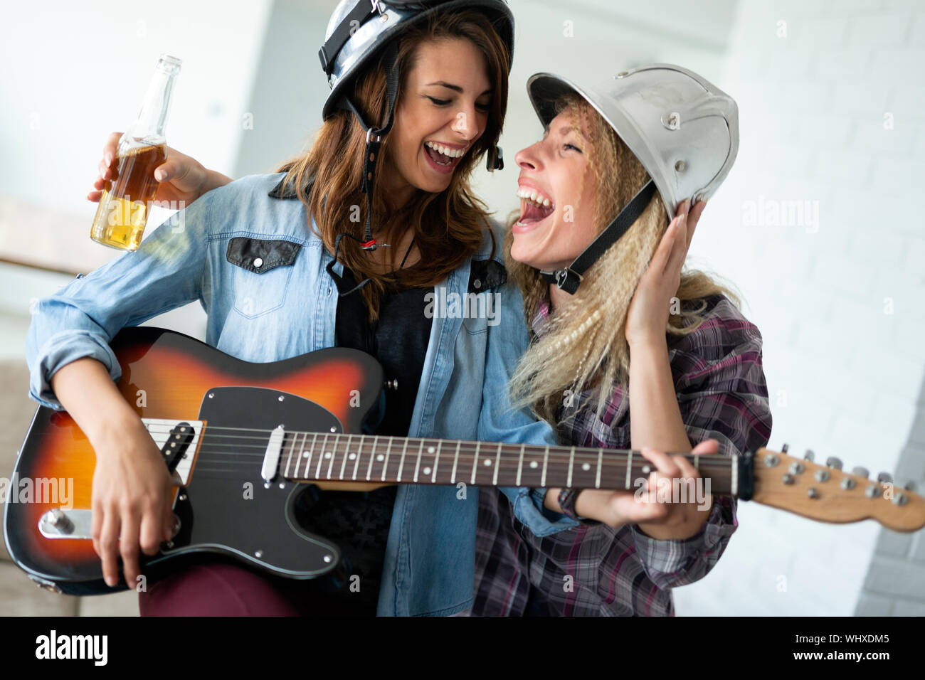 Group of young friends having fun together and playing in music band ...