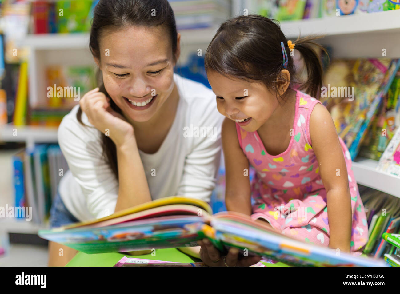 Parent and child reading books together in the library Stock Photo - Alamy