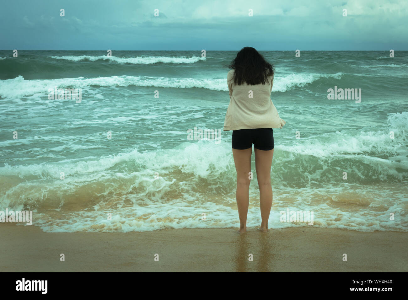 Sad depressed lonely woman standing in ocean crying, ready to give up ...