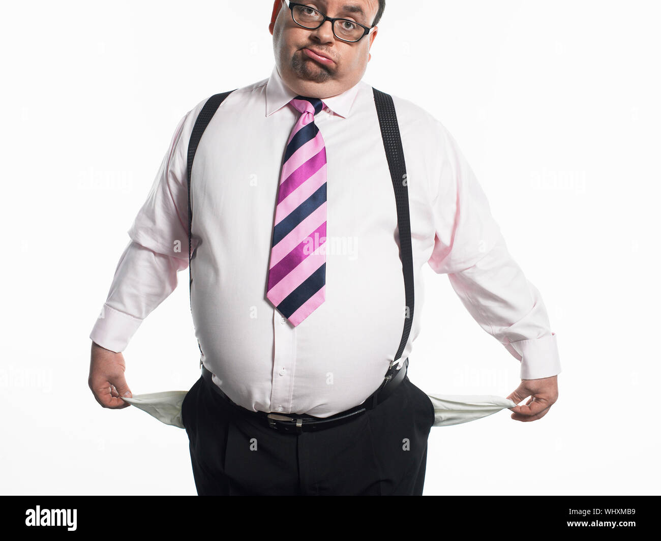 Portrait of an overweight businessman pulling out empty pockets against ...