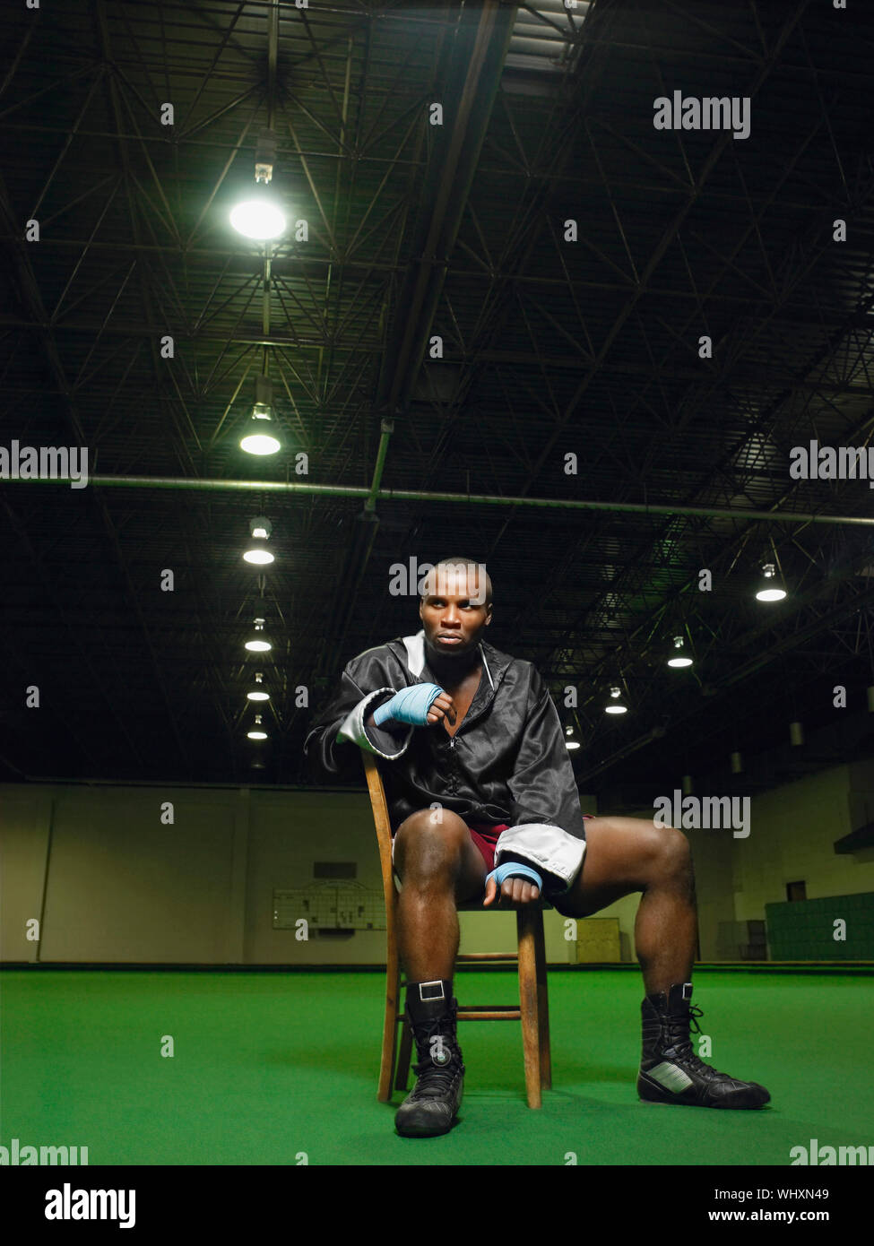 Full length portrait of an African American boxer sitting on chair ...