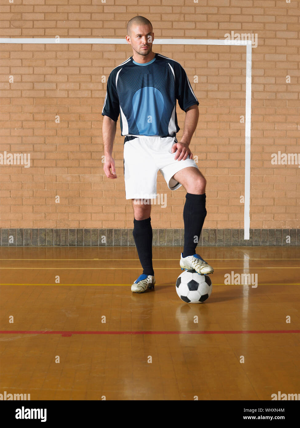 Full length portrait of a player with leg on football Stock Photo - Alamy