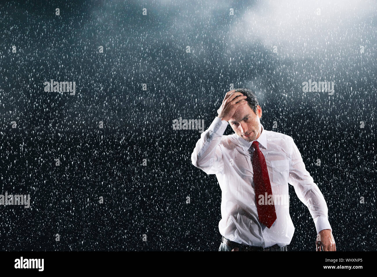 Portrait of a young businessman running fingers through wet hair in the ...