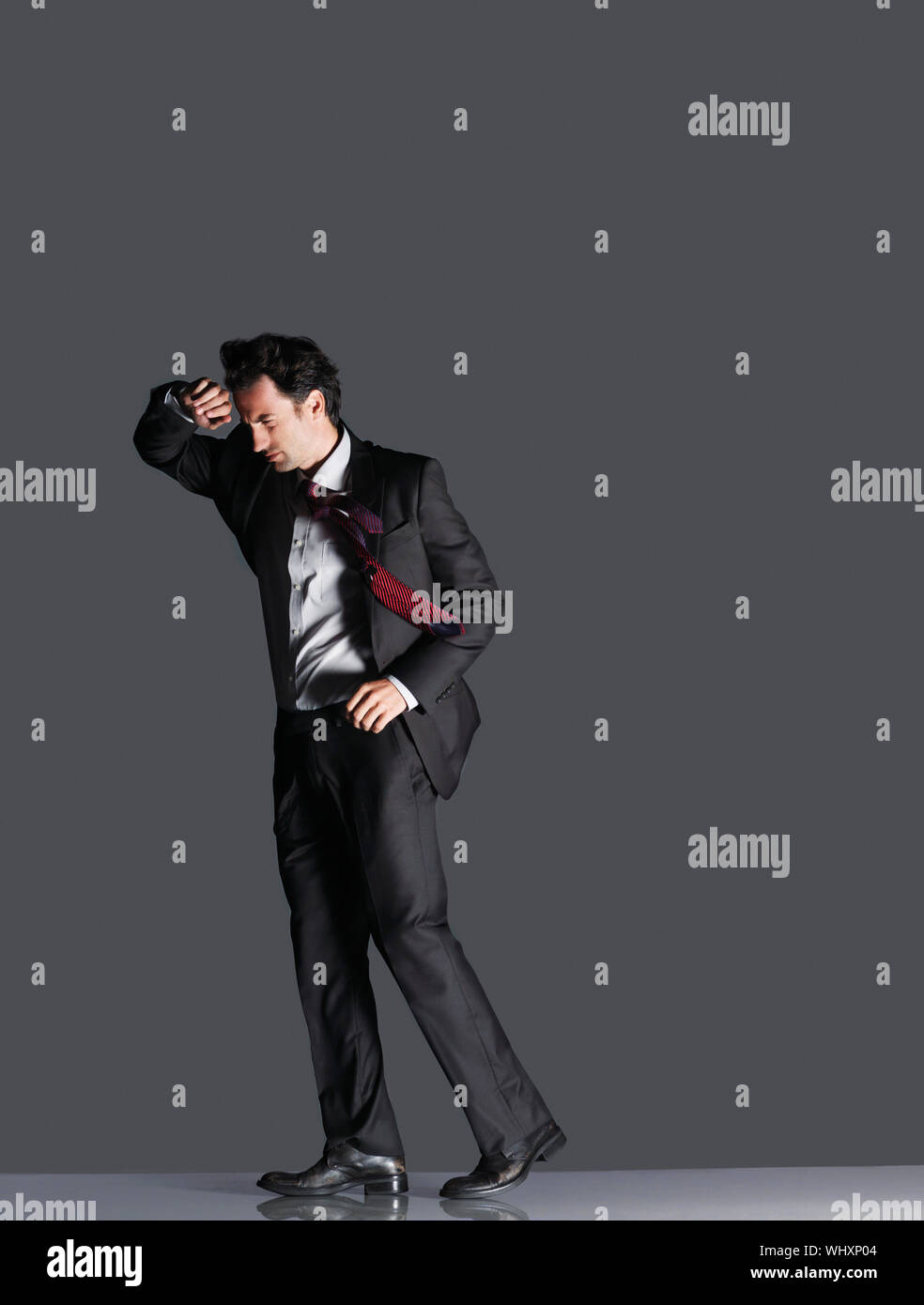 Full length side view of a young businessman shielding face with arm ...
