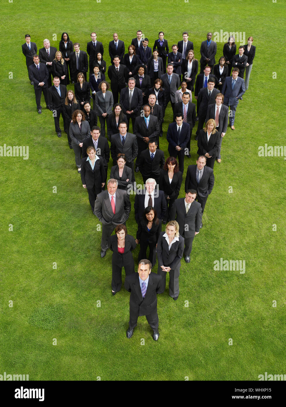 Elevated view of large group of business people standing in triangle ...