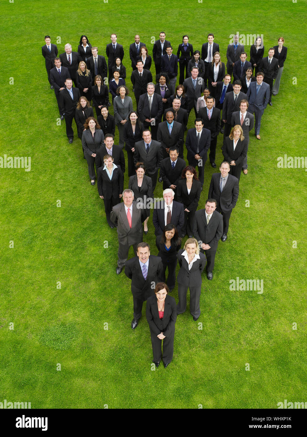 Elevated view of large group of business people standing in triangle ...