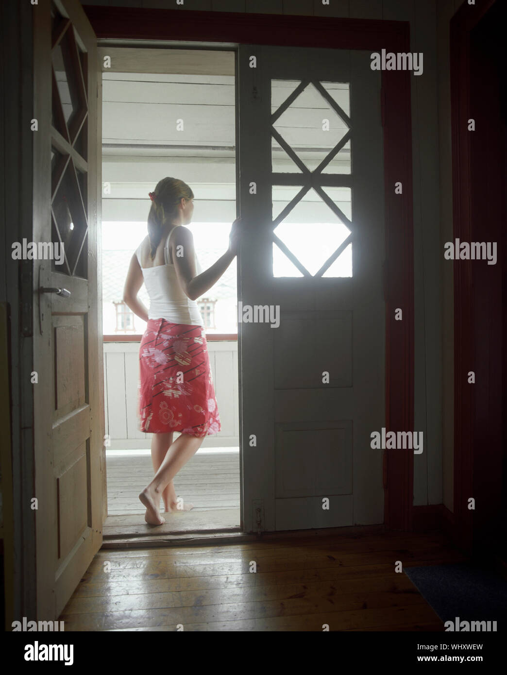 Full length rear view of a young woman standing in open door Stock ...