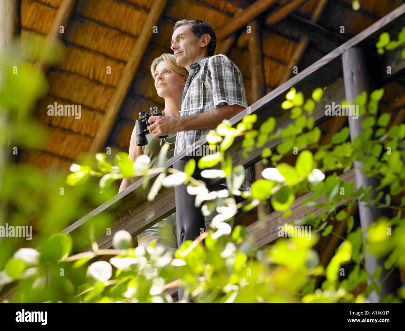 Low angle view of a couple on terrace with binoculars Stock Photo - Alamy