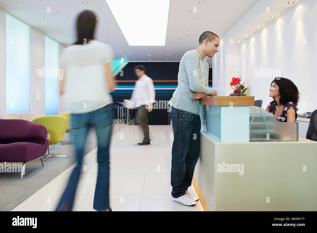 Man talking to receptionist at the reception desk in office Stock Photo ...