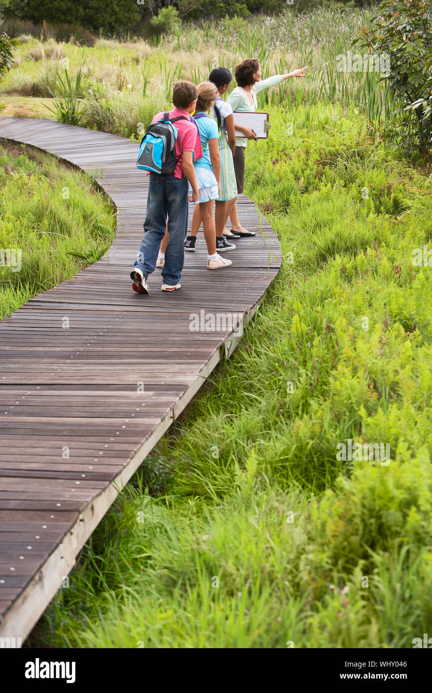 Teacher with children on nature field trip Stock Photo - Alamy