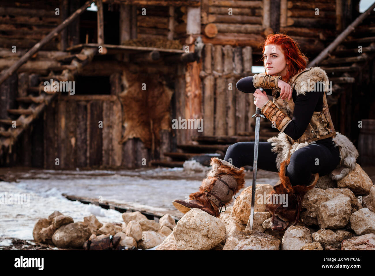 Red-haired woman is a Viking. Against the backdrop of a village or an ...
