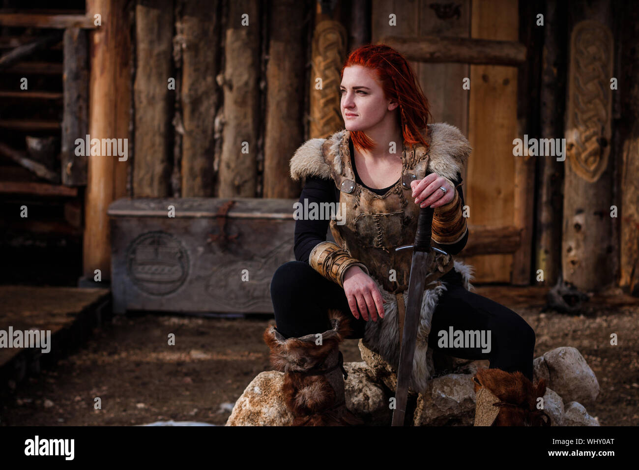 Red-haired woman is a Viking. Against the backdrop of a village or an ...