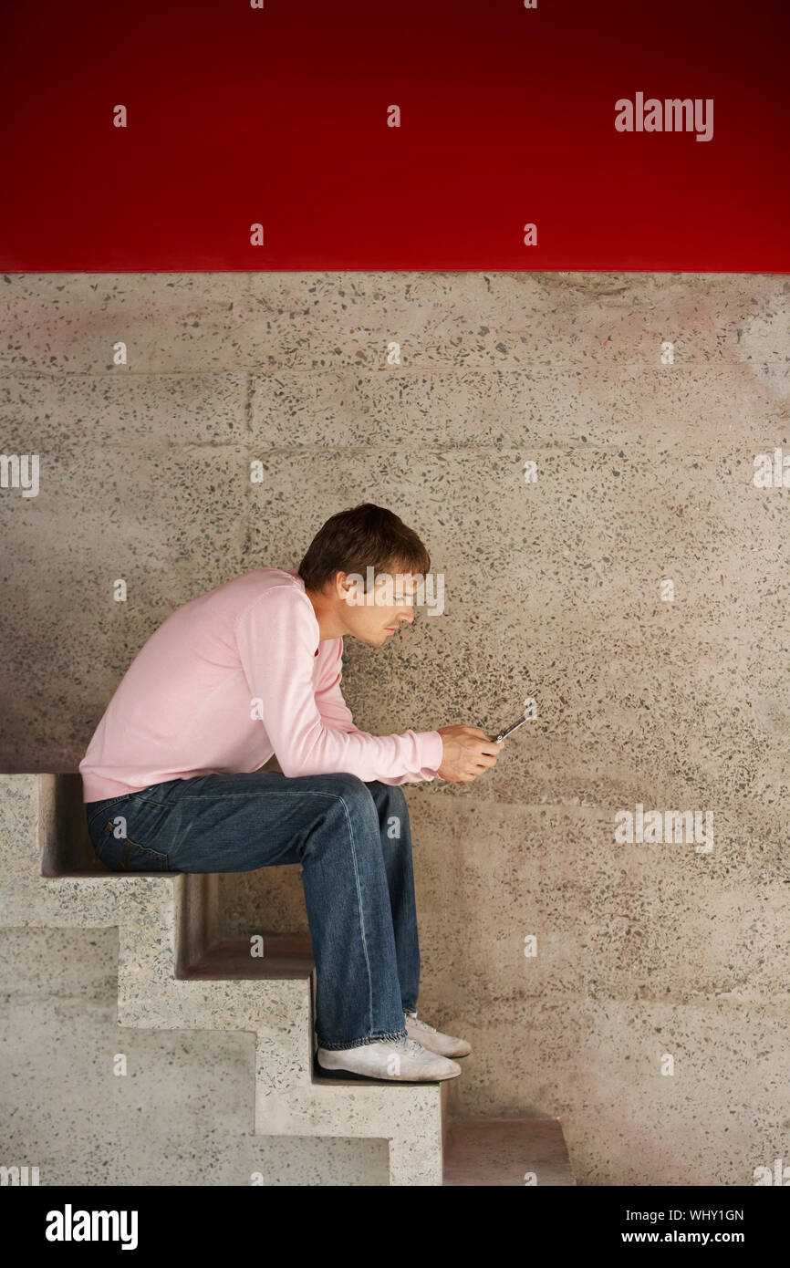 Man Using Cell Phone on Stairs Stock Photo - Alamy