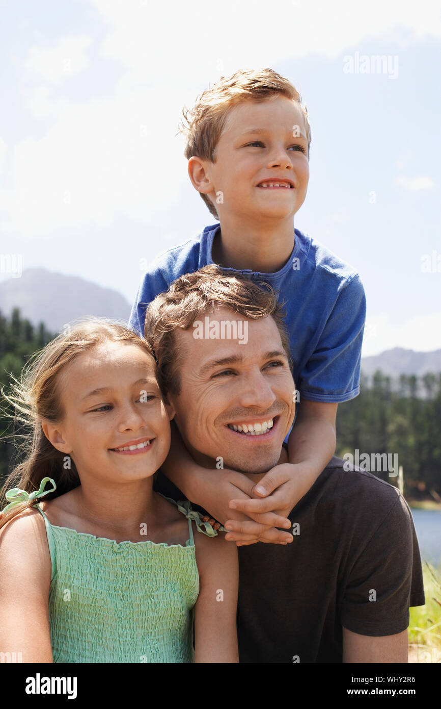 Happy father with children looking away outdoors Stock Photo - Alamy