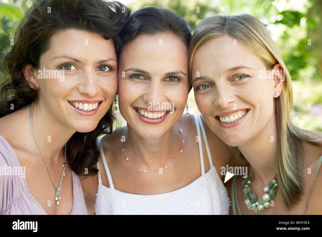 Closeup portrait of three female friends smiling together outdoors ...