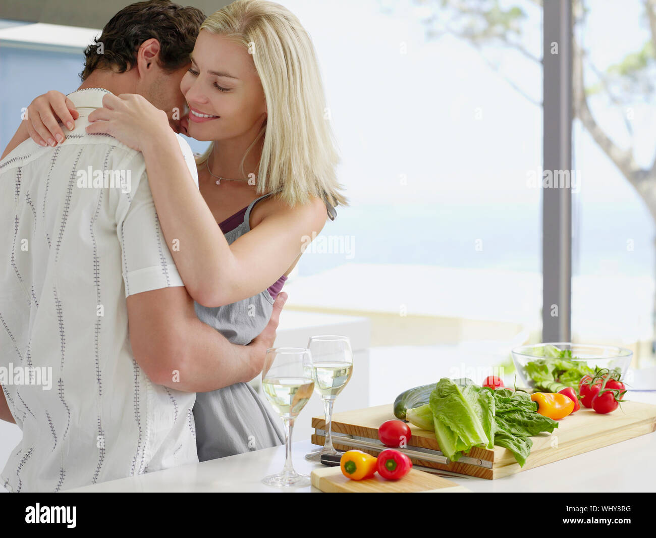 Romantic young couple embracing with fresh vegetables on kitchen ...
