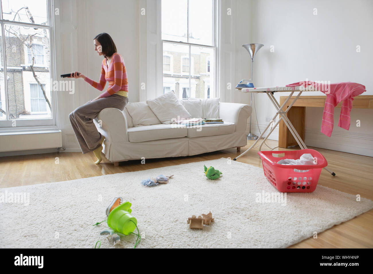 Woman sitting on edge sofa hi-res stock photography and images - Alamy