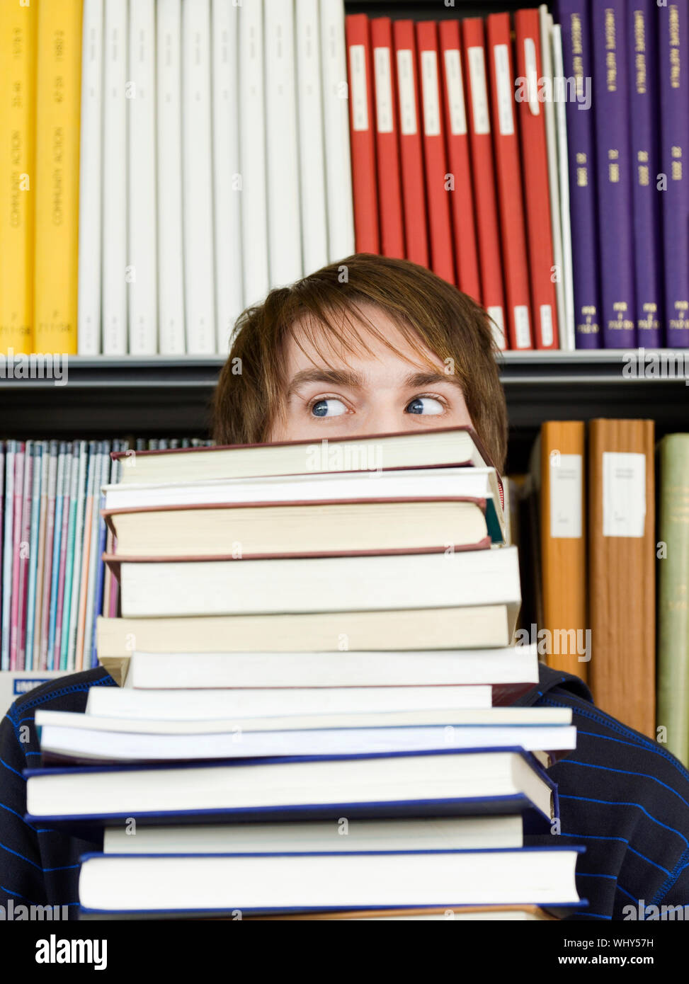 Closeup of a colleague student carrying stack of books in library Stock ...