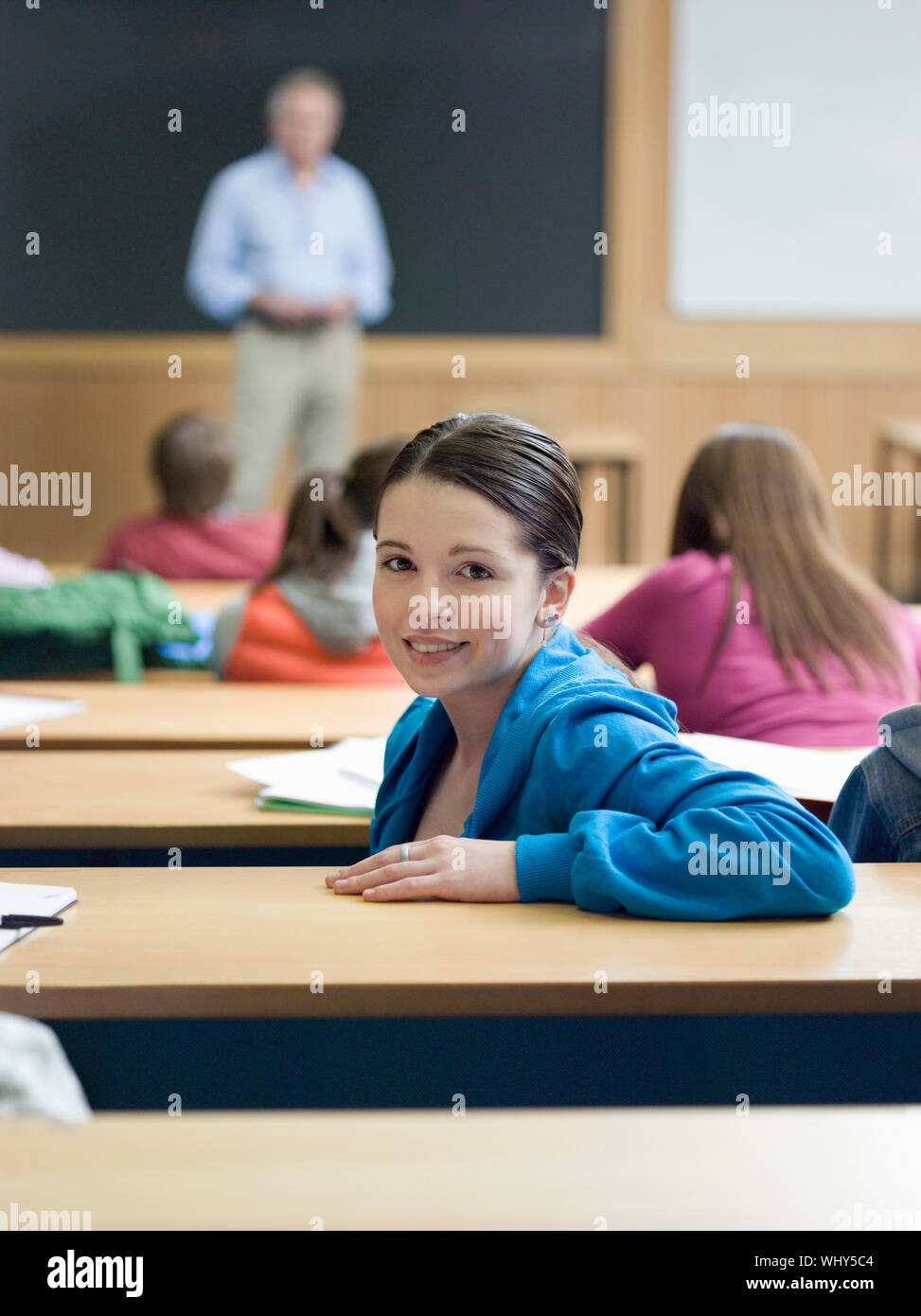 Portrait of a female in lecture room with blurred students Stock Photo ...