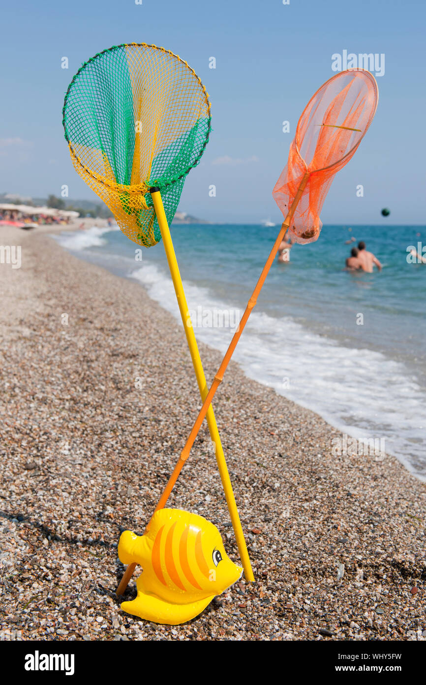Beach with fishing nets and toys in the sand Stock Photo - Alamy