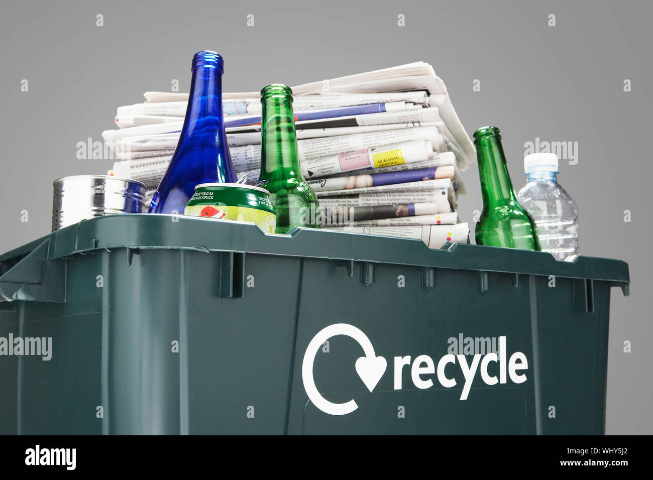 Recycling bin filled with waste paper and bottles close-up Stock Photo ...