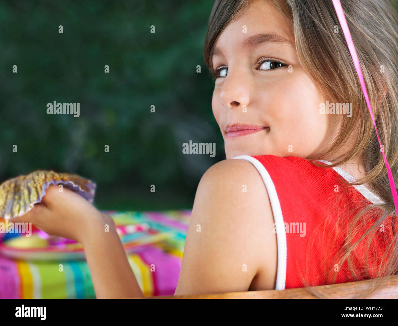 Closeup portrait of cute young girl looking over shoulder outdoors ...
