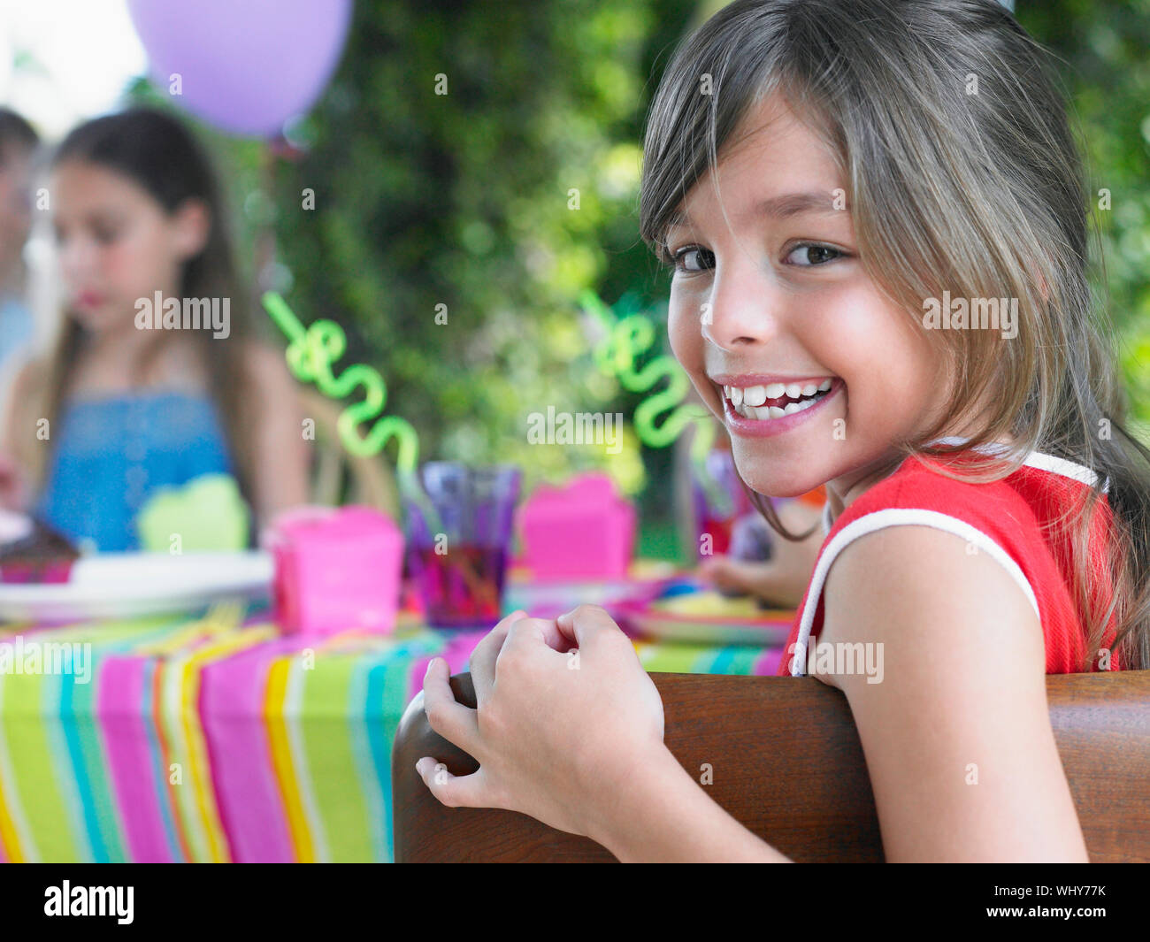 Closeup portrait of cute young girl looking over shoulder outdoors ...