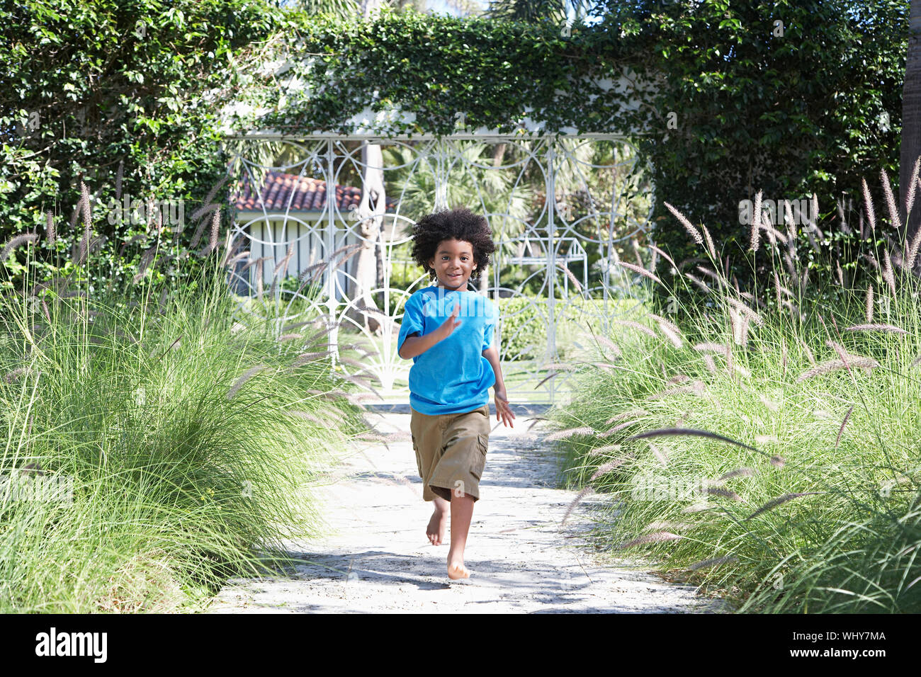 Full length portrait of young African American boy running on path ...