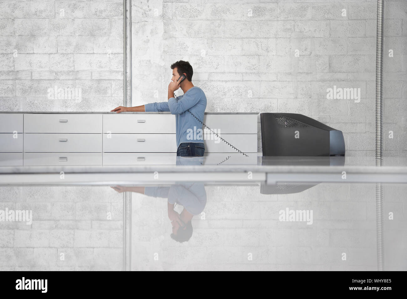 Young businessman using landline phone in office Stock Photo - Alamy