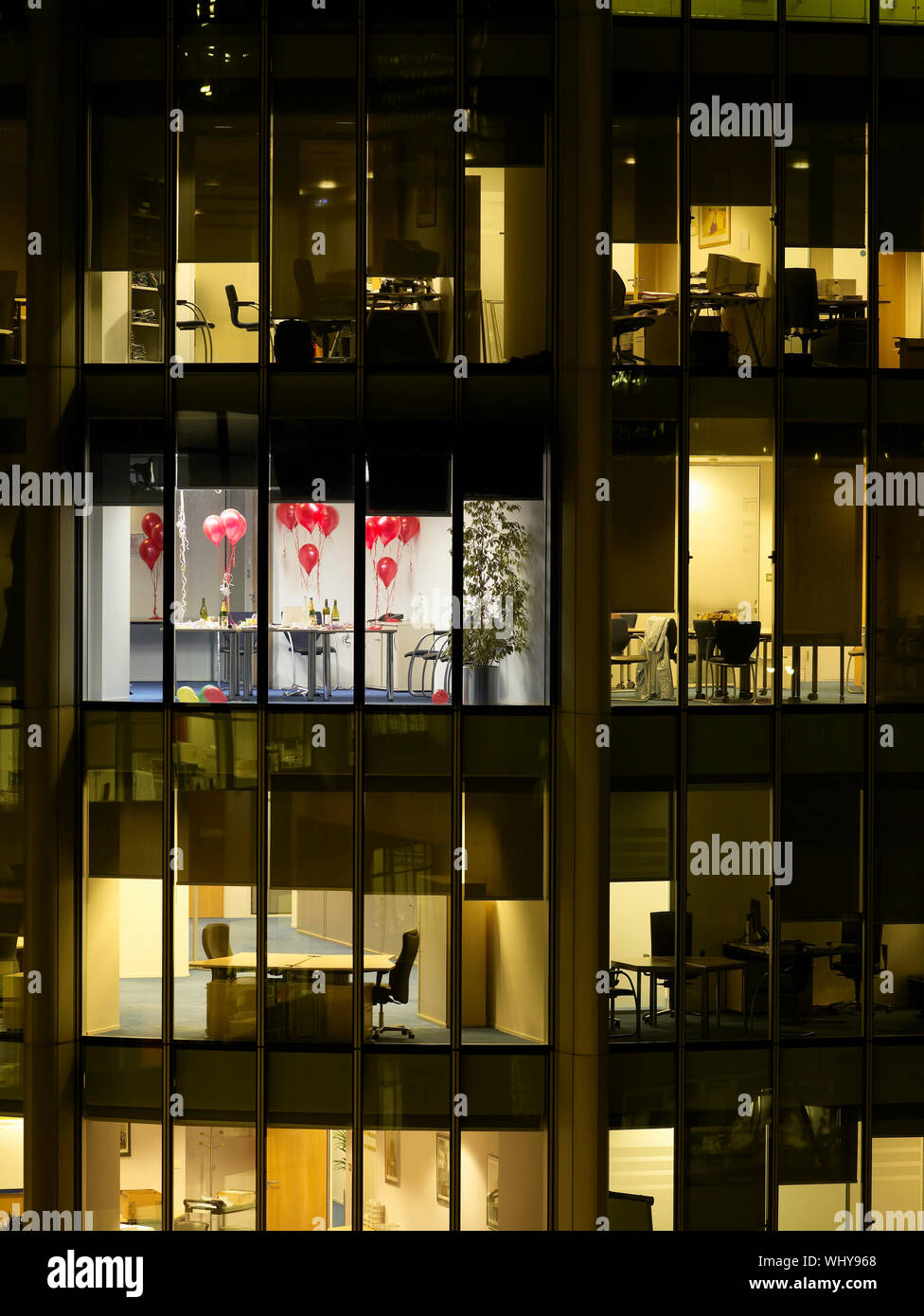 View of empty office decorated with balloons after party through window ...
