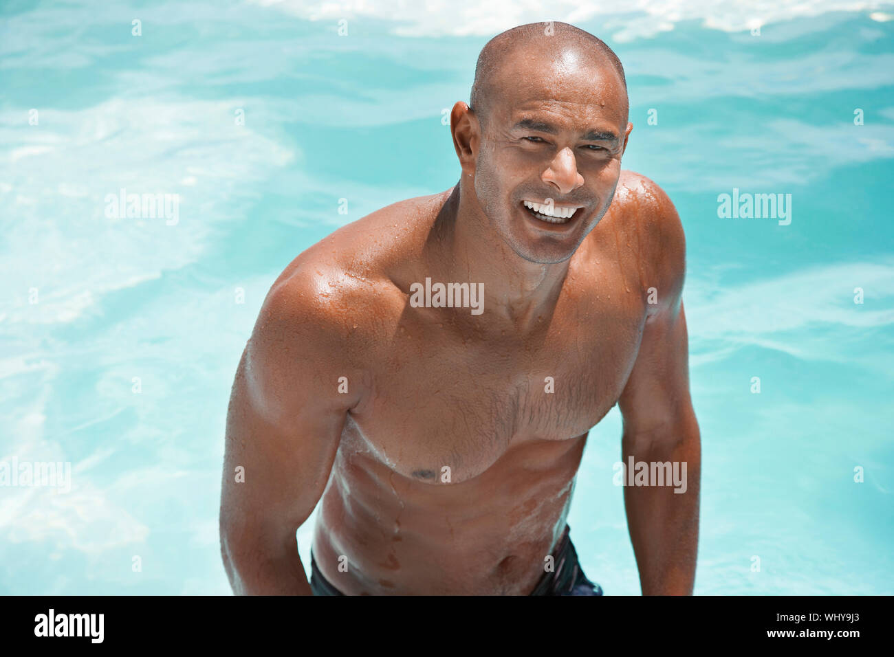 Portrait of shirtless African American man in swimming pool smiling ...